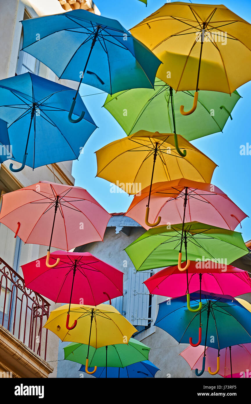Colourful umbrellas hanging between buildings above a street in the old ...