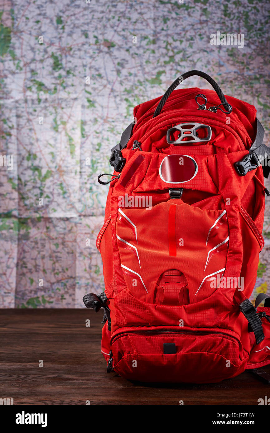 Orange big hiking backpack for the travelling against map background ...