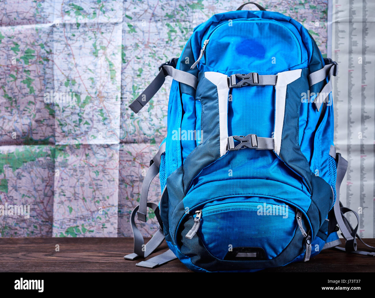 Tourist blue backpack against map background Stock Photo - Alamy