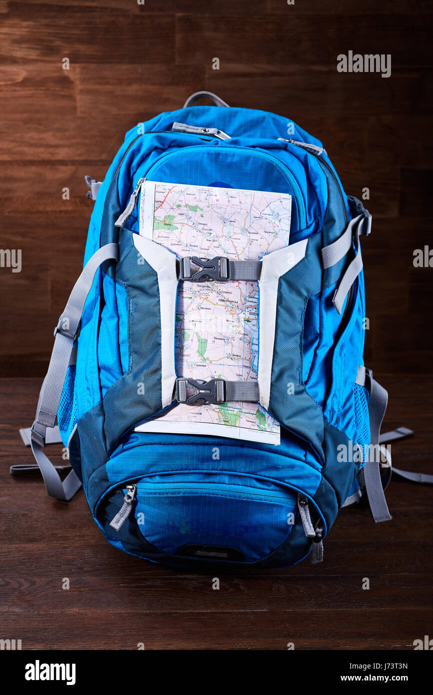 Tourist blue big backpack and map against wooden background Stock Photo ...