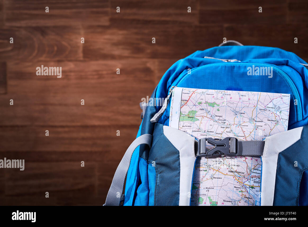 Tourist blue big backpack and map against wooden background Stock Photo ...
