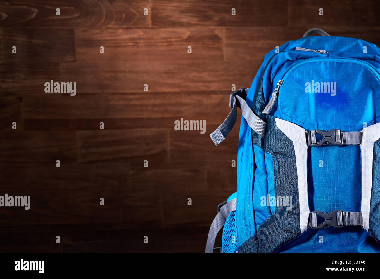 Tourist blue backpack against wooden background Stock Photo - Alamy
