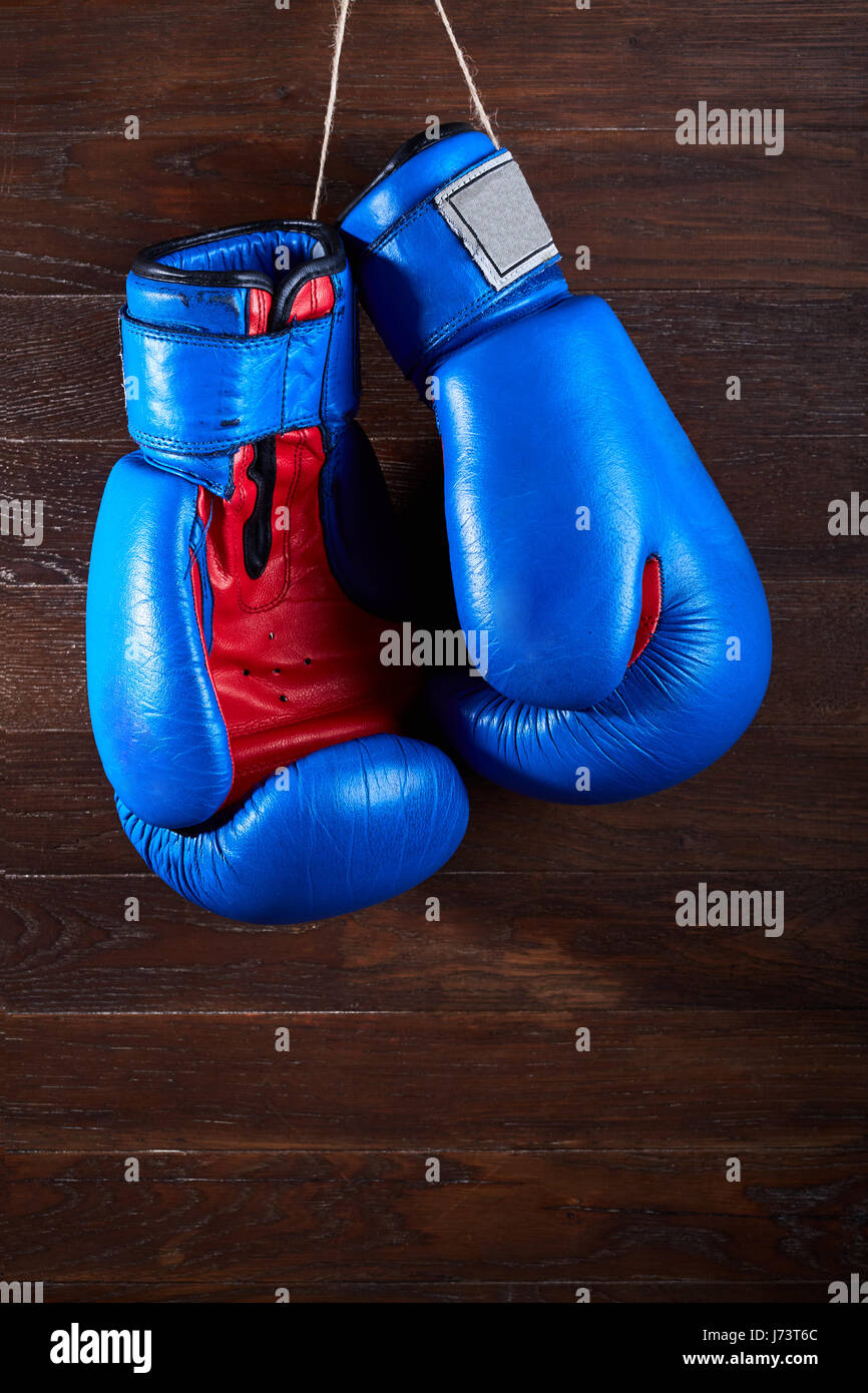 Blue and red boxing gloves hanging on wooden wall Stock Photo - Alamy