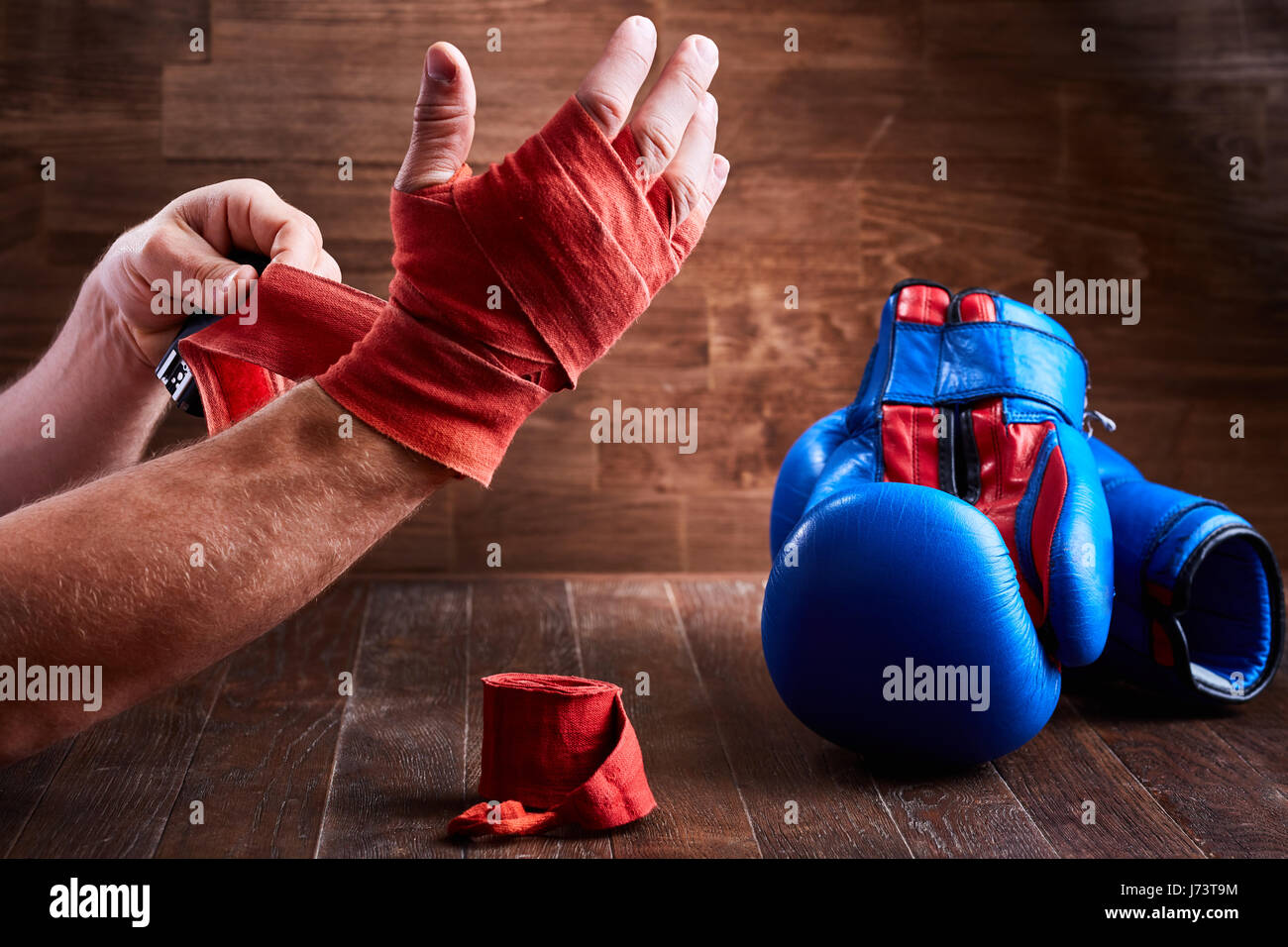 Sportive man wrapping his hands with bandage and boxing gloves on ...