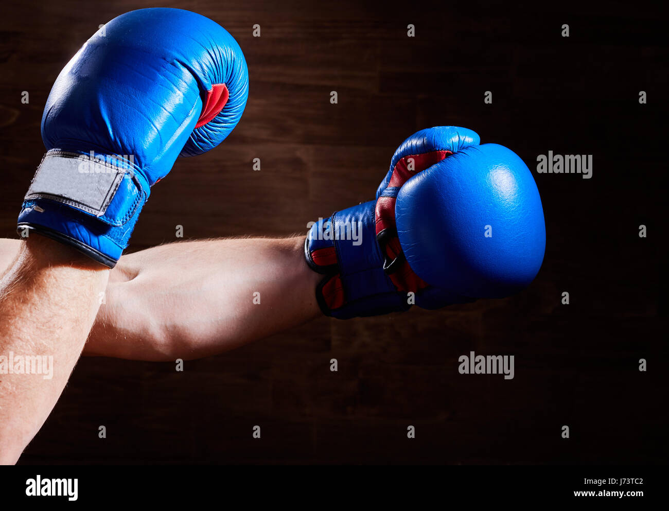 Blue and red boxing gloves on hands on brown background Stock Photo - Alamy
