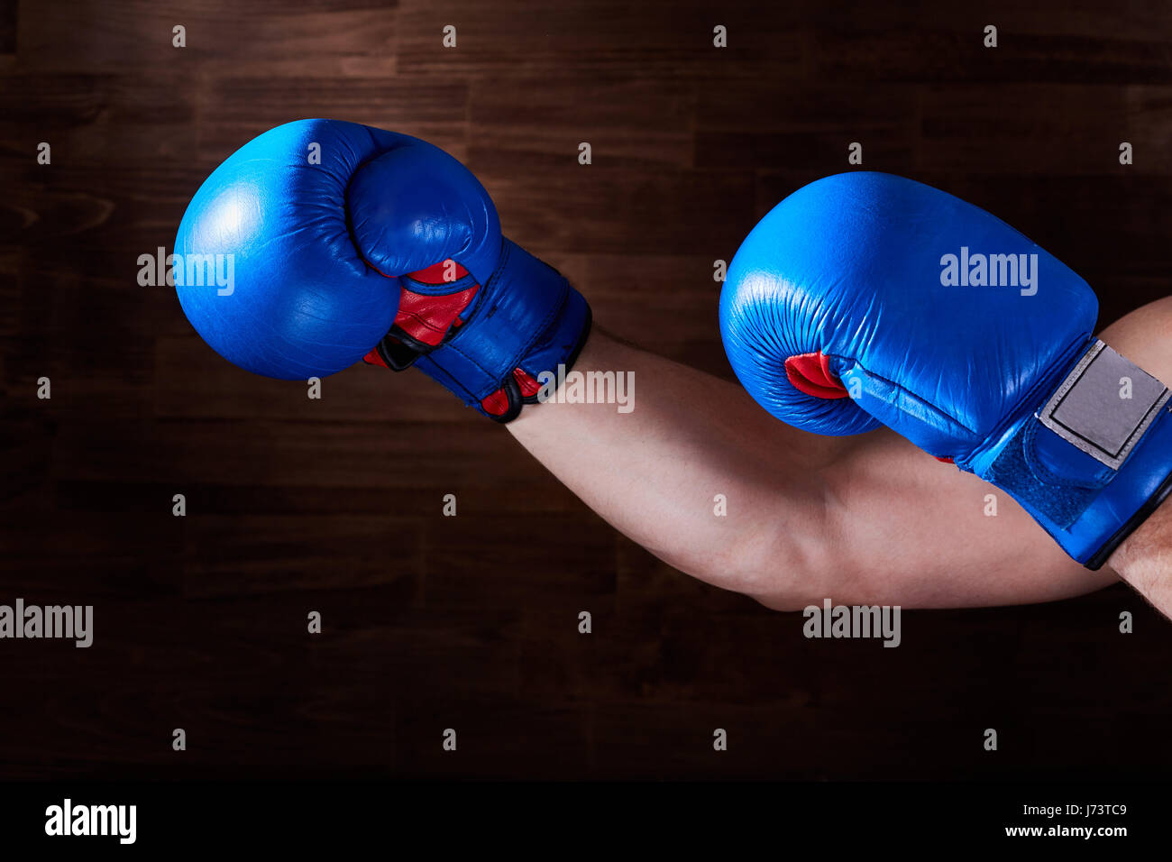 Blue and red boxing gloves on hands on brown background Stock Photo - Alamy