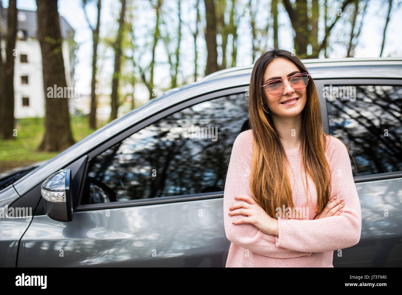 Young happy woman standing by her car with hands Stock Photo - Alamy