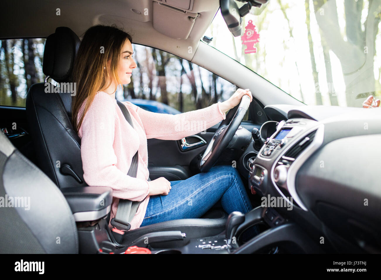 side view of Woman driving her car on street Stock Photo - Alamy