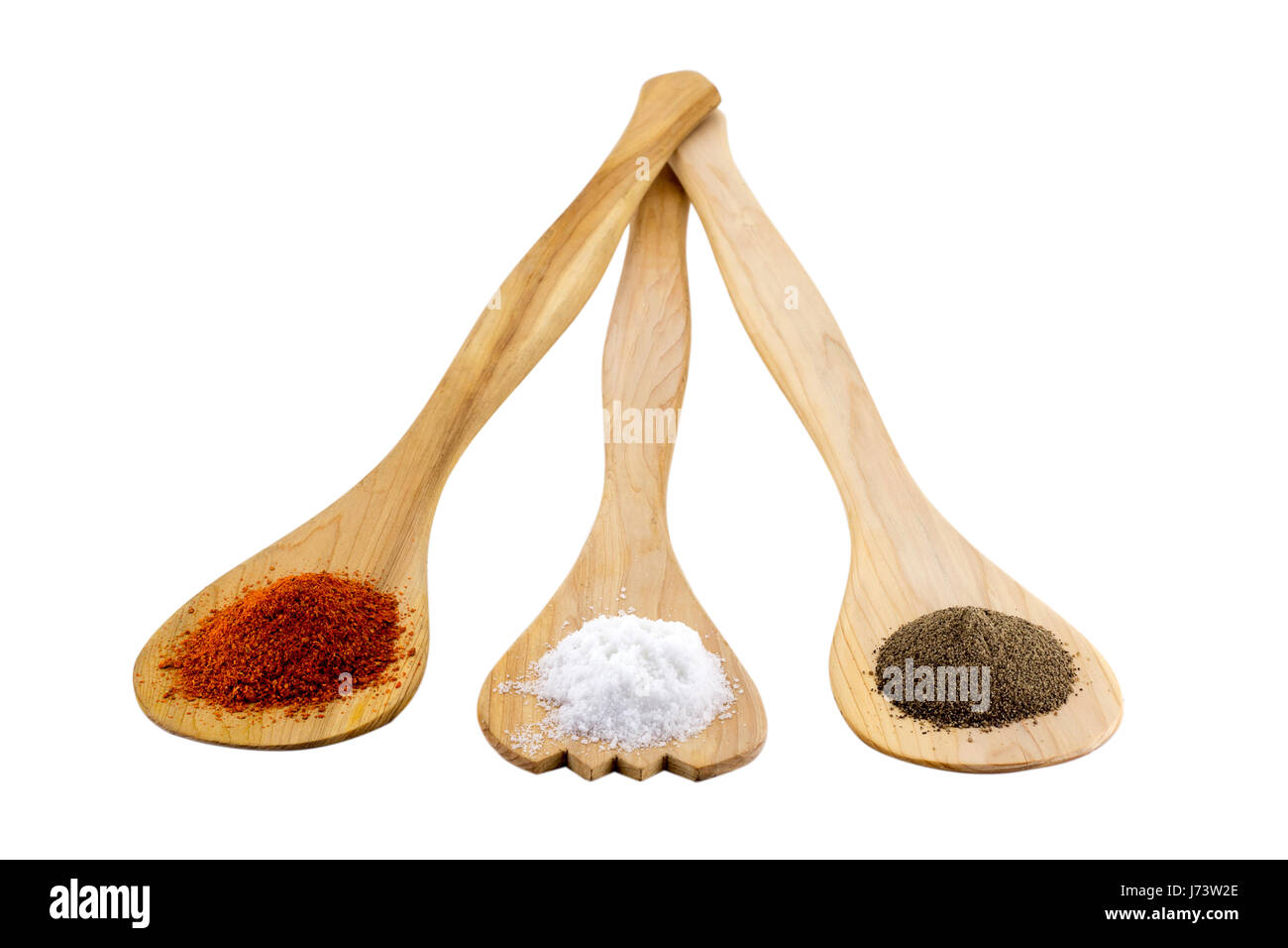 Three royal spices on wooden spoons, salt, black pepper, chilli pepper ...