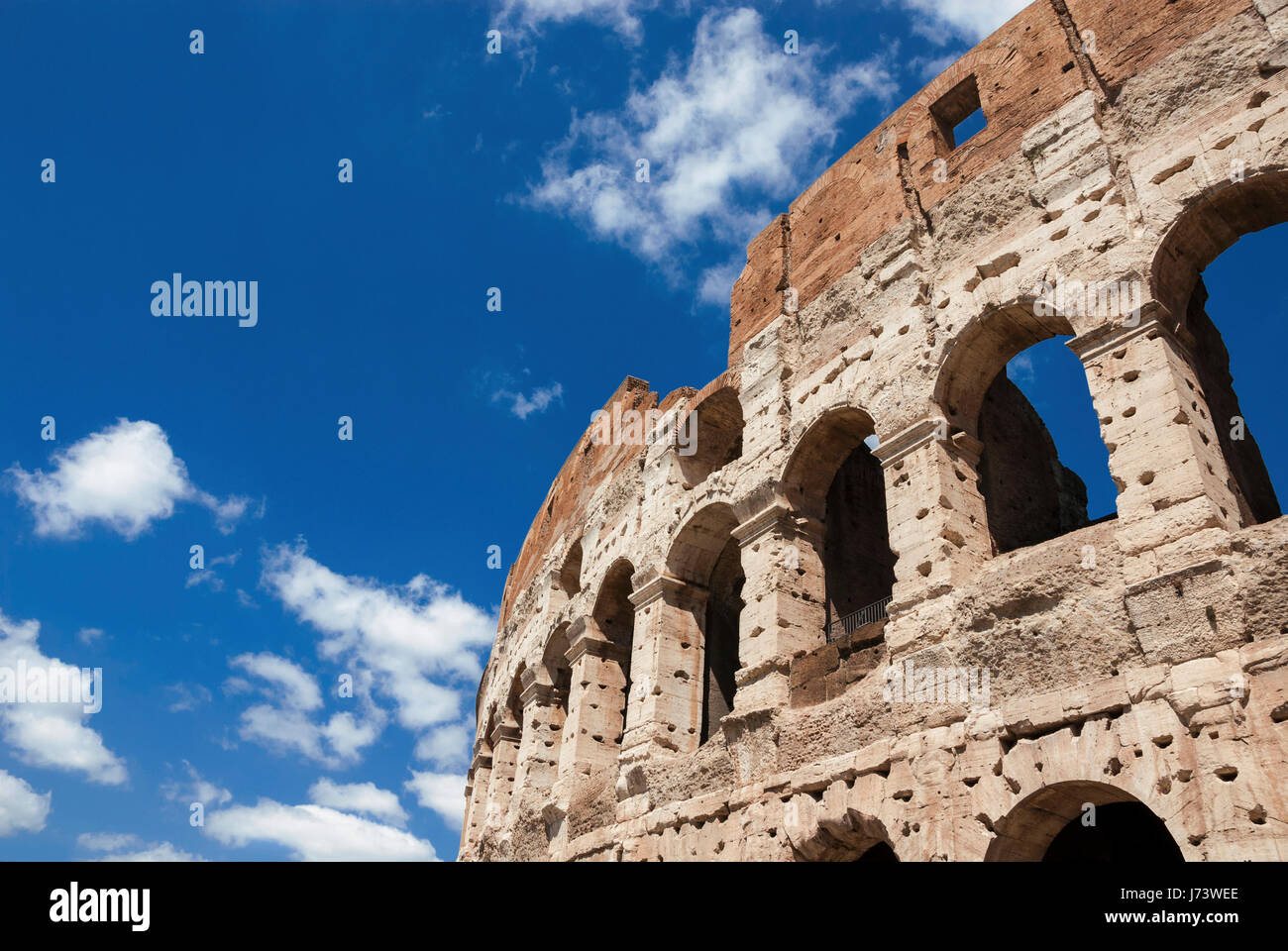 Coliseum monumental arcades with blue sky in Rome Stock Photo - Alamy