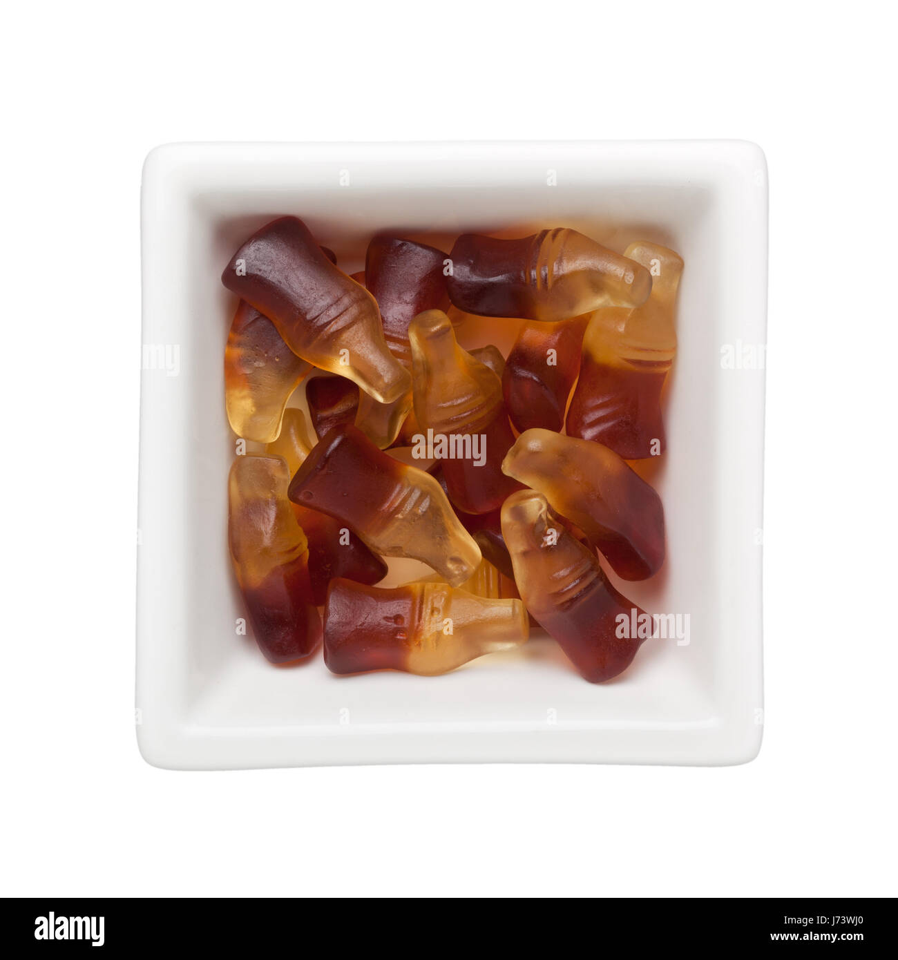 Cola flavored gummies in a square bowl isolated on white background ...