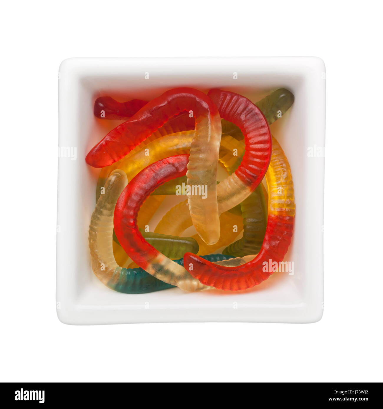 Worm shaped gummies in a square bowl isolated on white background Stock ...