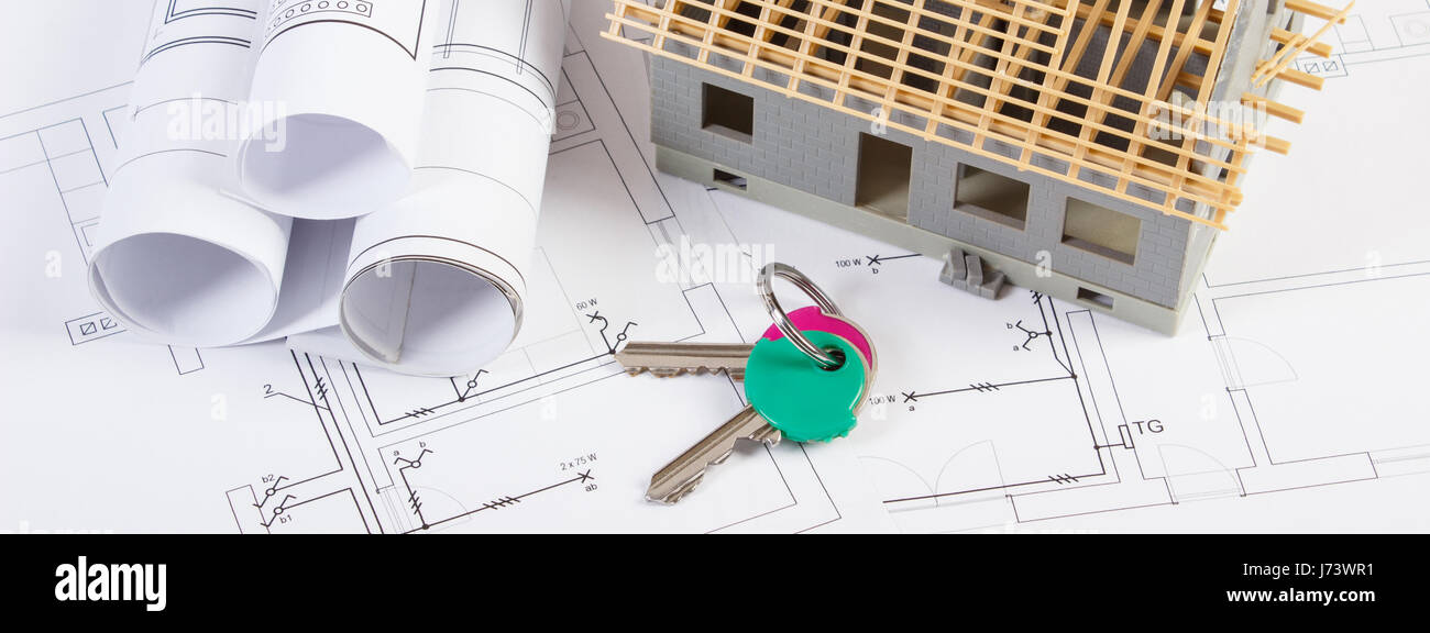 Small house under construction, home keys and electrical rolls of ...