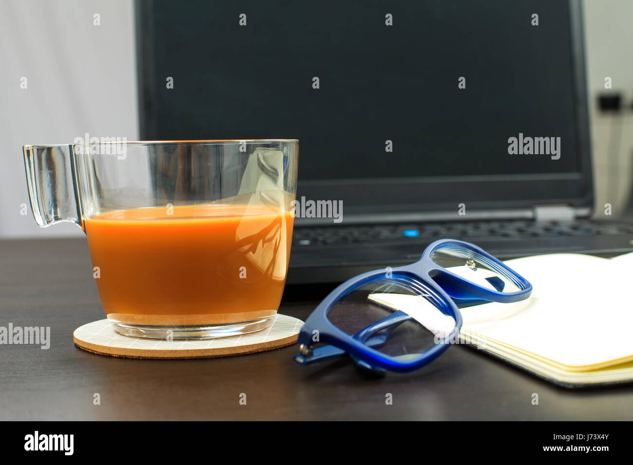 Office desk with coffee, laptop, glasses, and notepad Stock Photo - Alamy