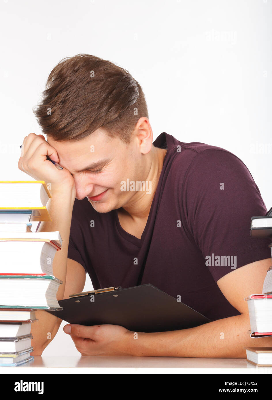 Tired young student sitting at his desk and learns for his exams Stock ...