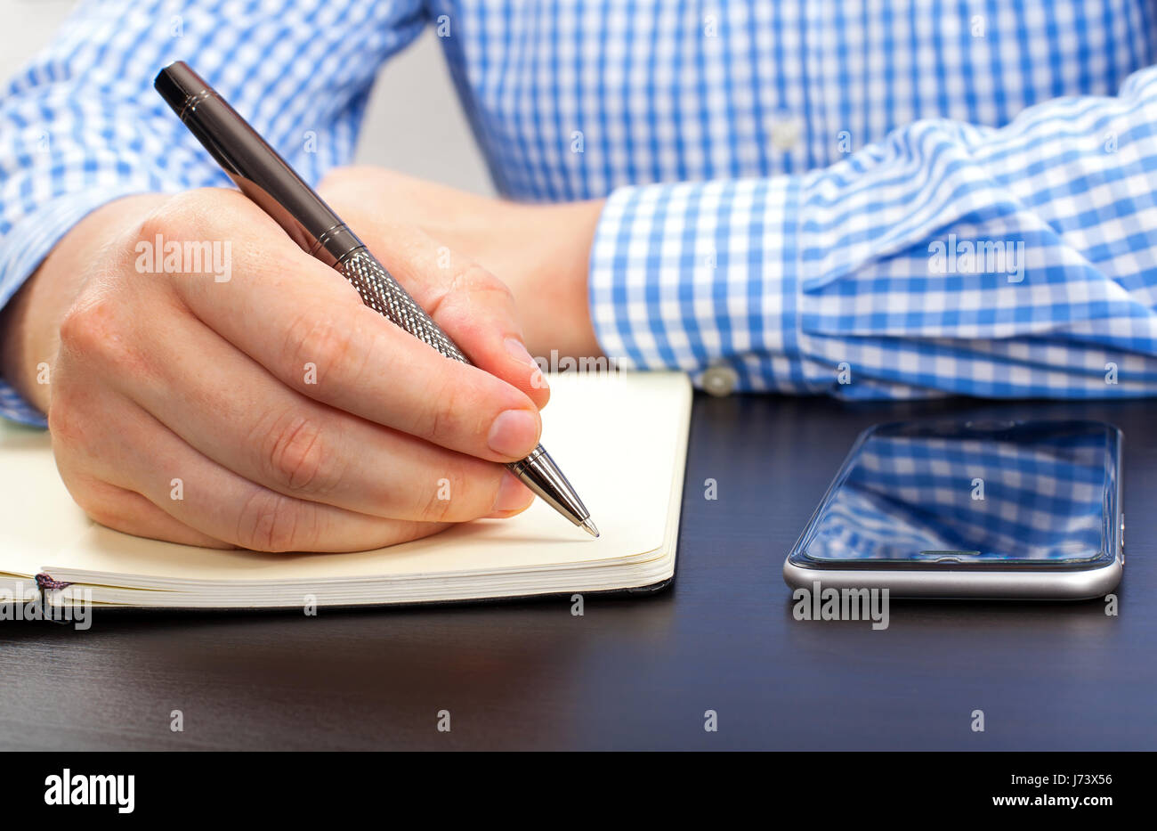 Businessman's hand writing notes while working at office Stock Photo ...