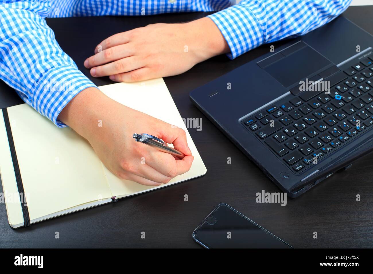 Businessman's hand writing notes while working at office Stock Photo ...