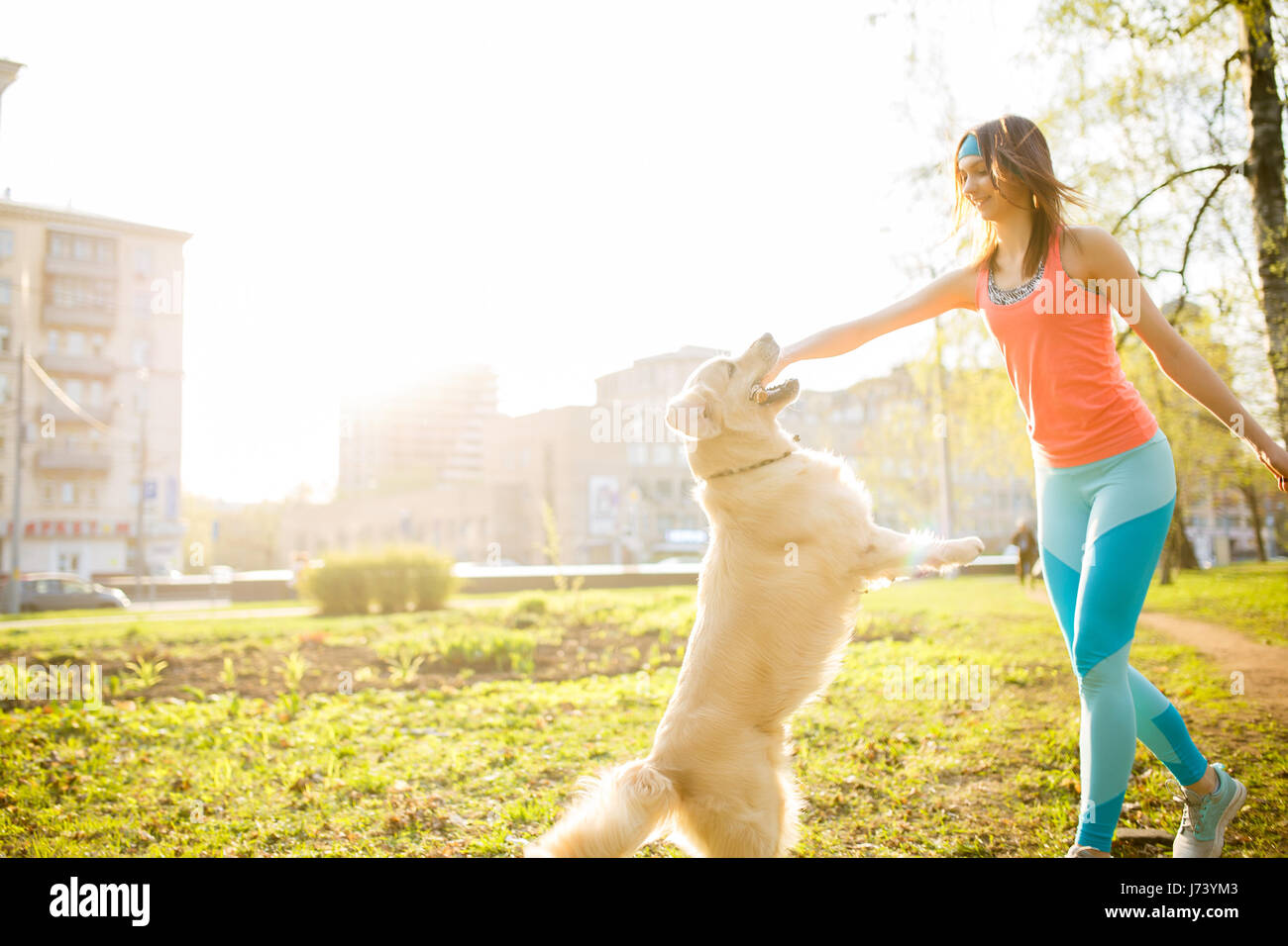 Young brunette playing with dog Stock Photo - Alamy