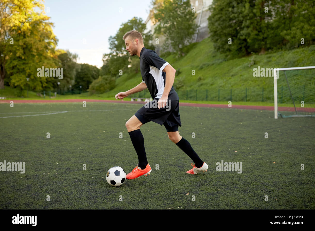soccer player playing with ball on football field Stock Photo - Alamy