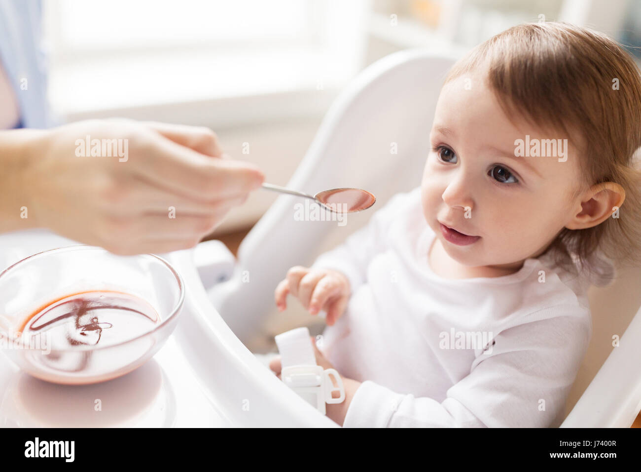 mother feeding baby with puree at home Stock Photo - Alamy