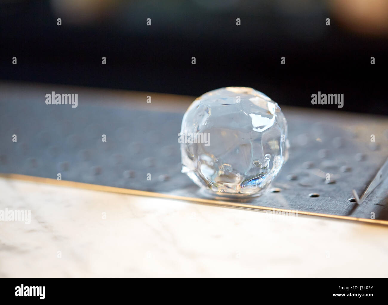 hand-cut ice ball at bar Stock Photo - Alamy