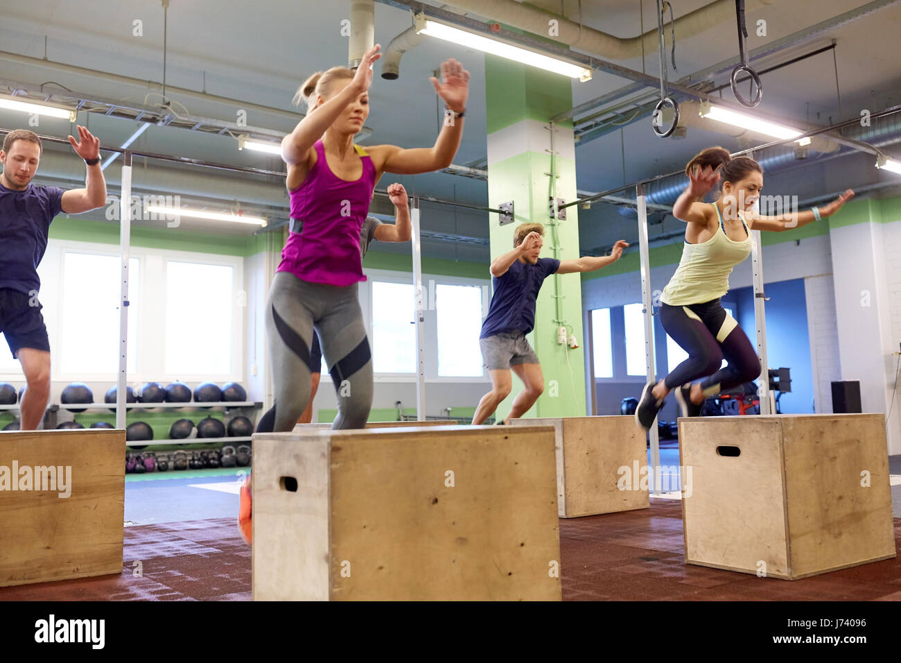 group of people doing box jumps exercise in gym Stock Photo - Alamy