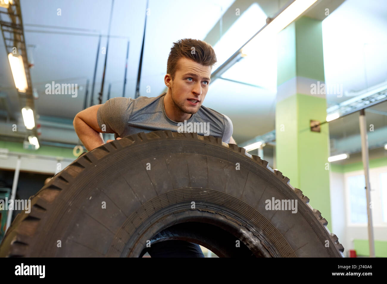 man doing strongman tire flip training in gym Stock Photo - Alamy