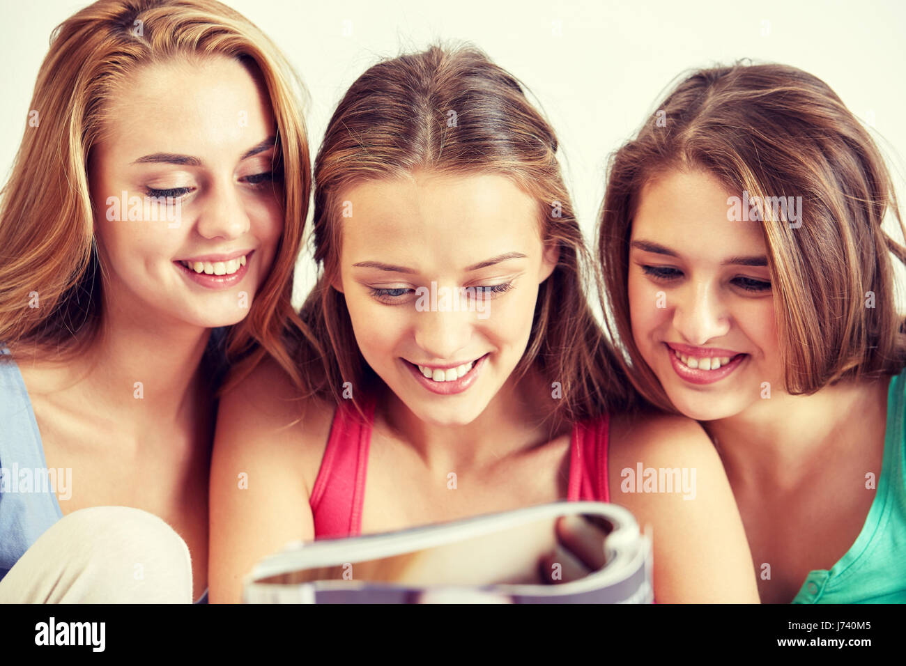 friends or teen girls reading magazine at home Stock Photo - Alamy