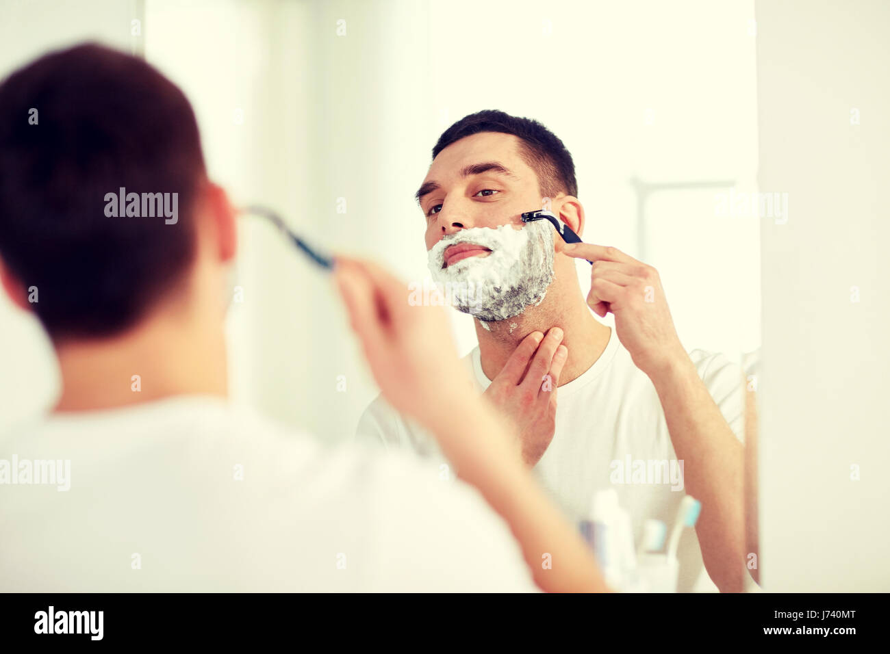 man shaving beard with razor blade at bathroom Stock Photo - Alamy