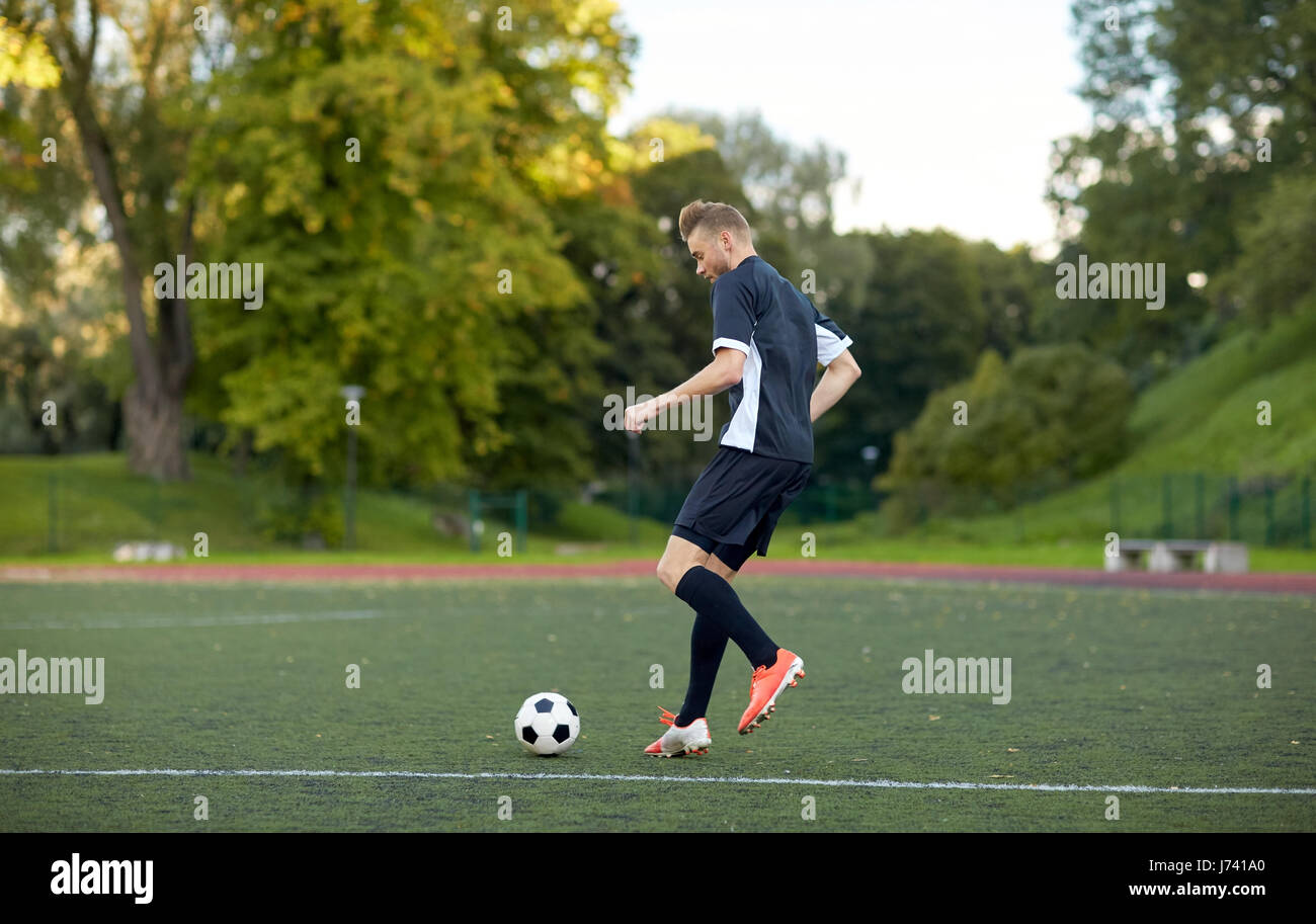 soccer player playing with ball on football field Stock Photo - Alamy