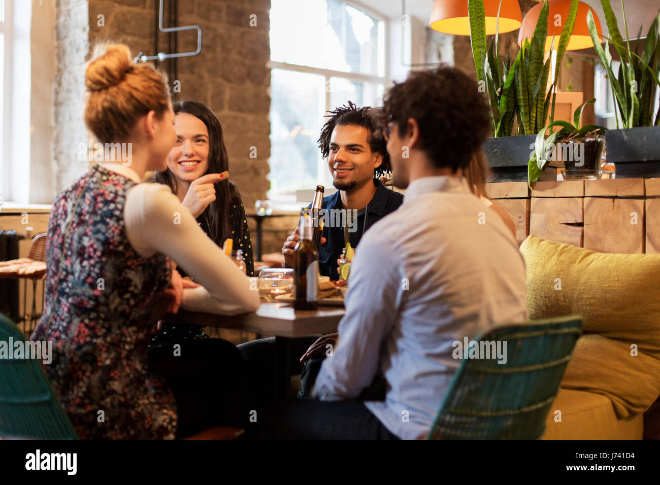 happy friends eating and drinking at bar or cafe Stock Photo - Alamy