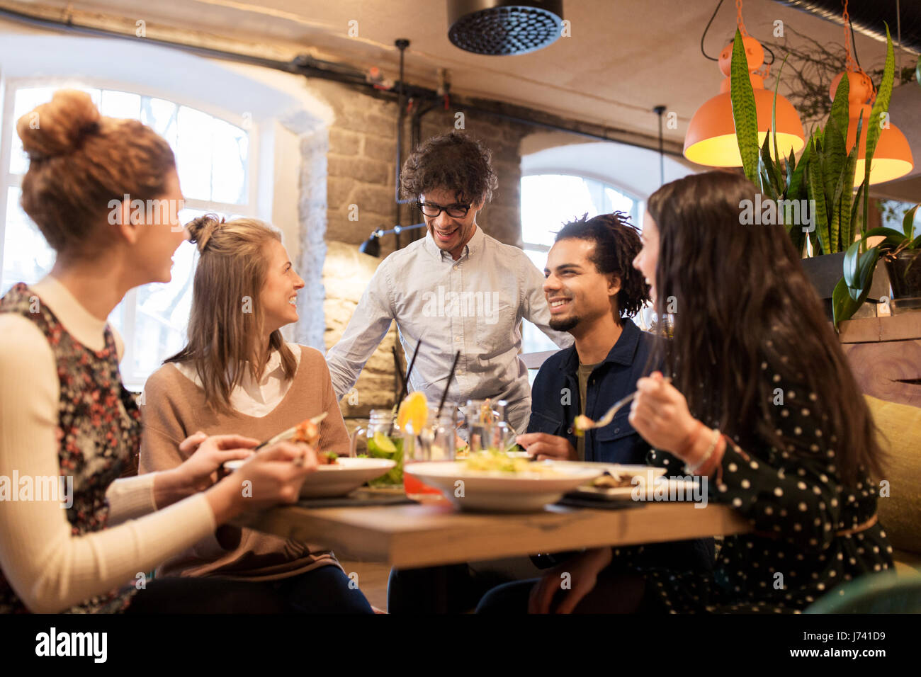 happy friends eating and drinking at restaurant Stock Photo - Alamy