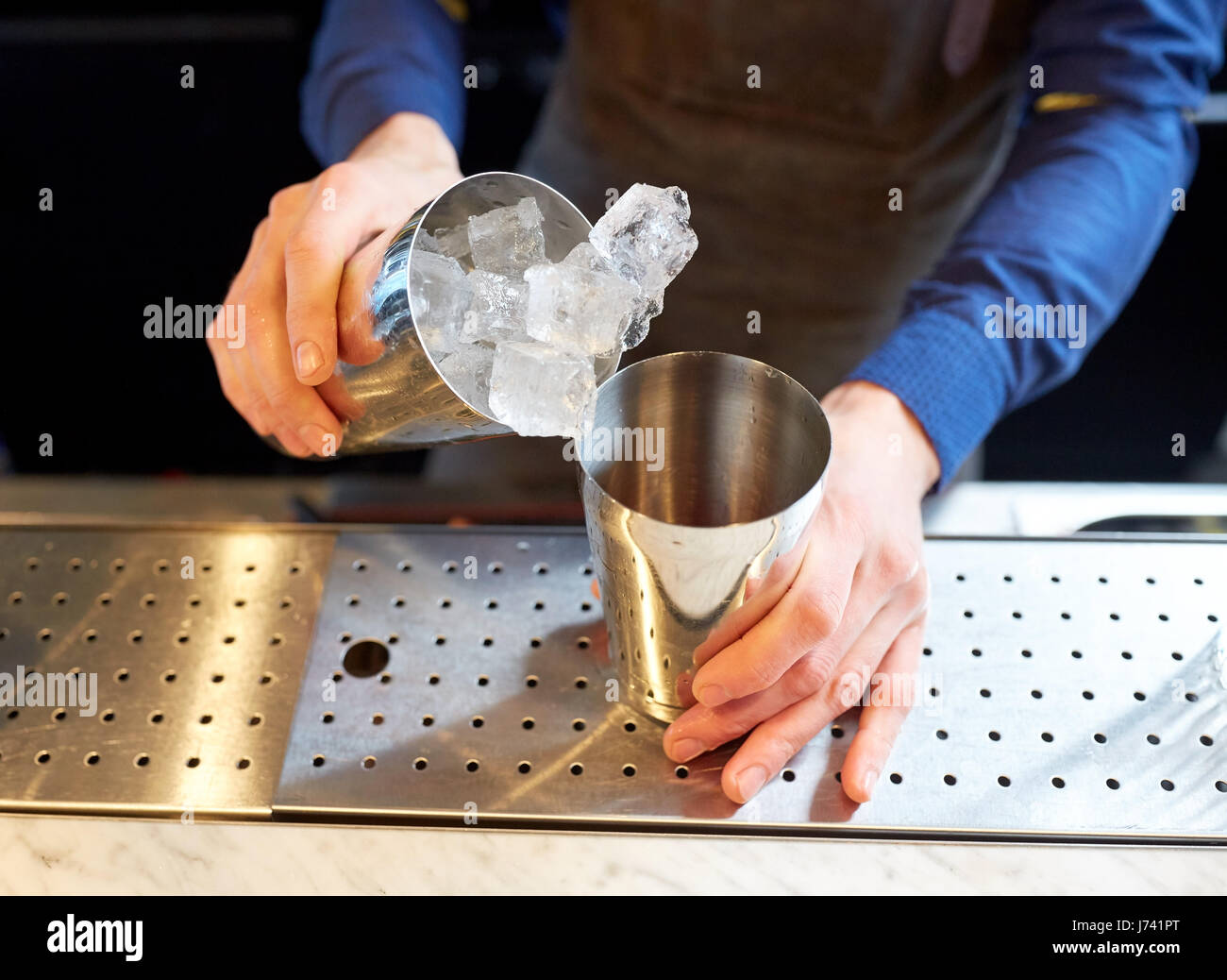 bartender with ice and shaker at cocktail bar Stock Photo - Alamy