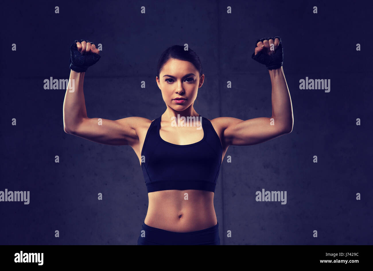 young woman flexing muscles in gym Stock Photo - Alamy