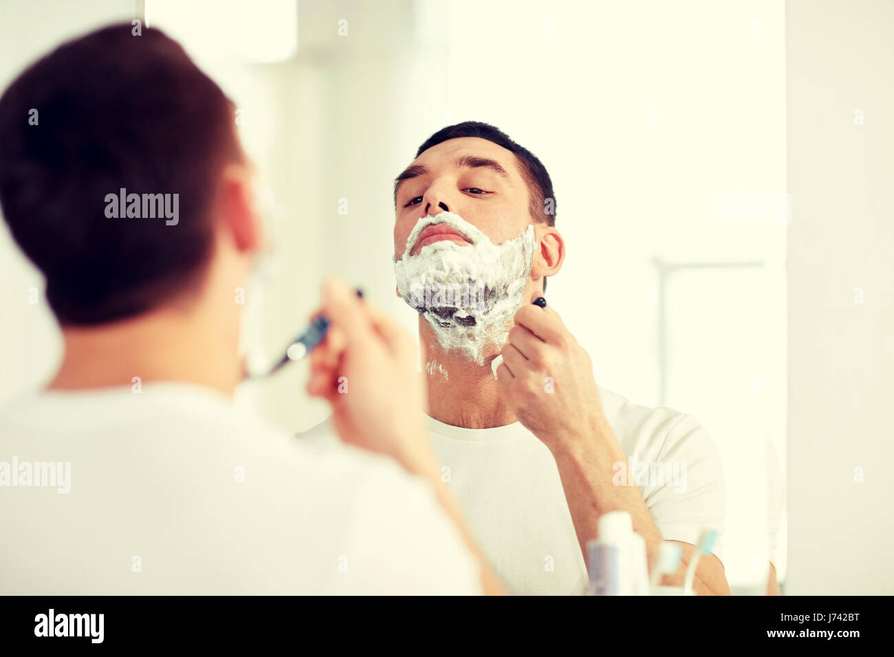 man shaving beard with razor blade at bathroom Stock Photo - Alamy