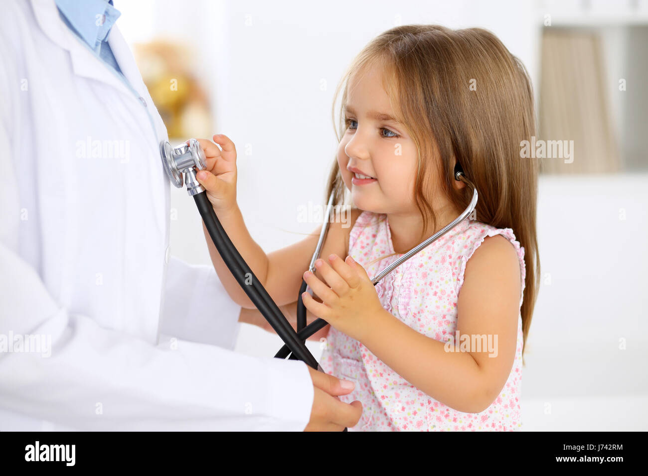 Happy little girl at health exam at doctor's office Stock Photo - Alamy