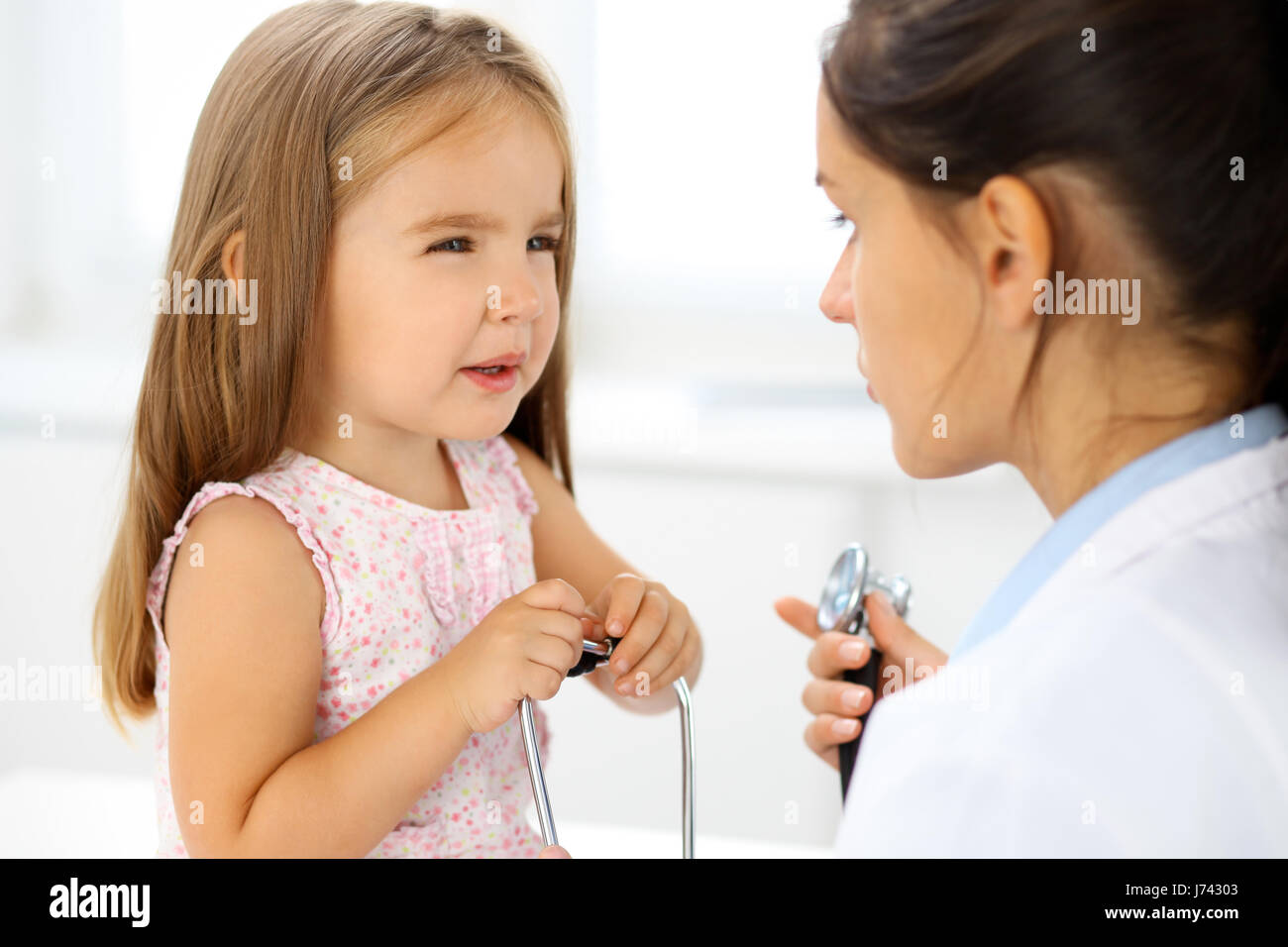 Happy little girl at health exam at doctor office. Medicine and health ...