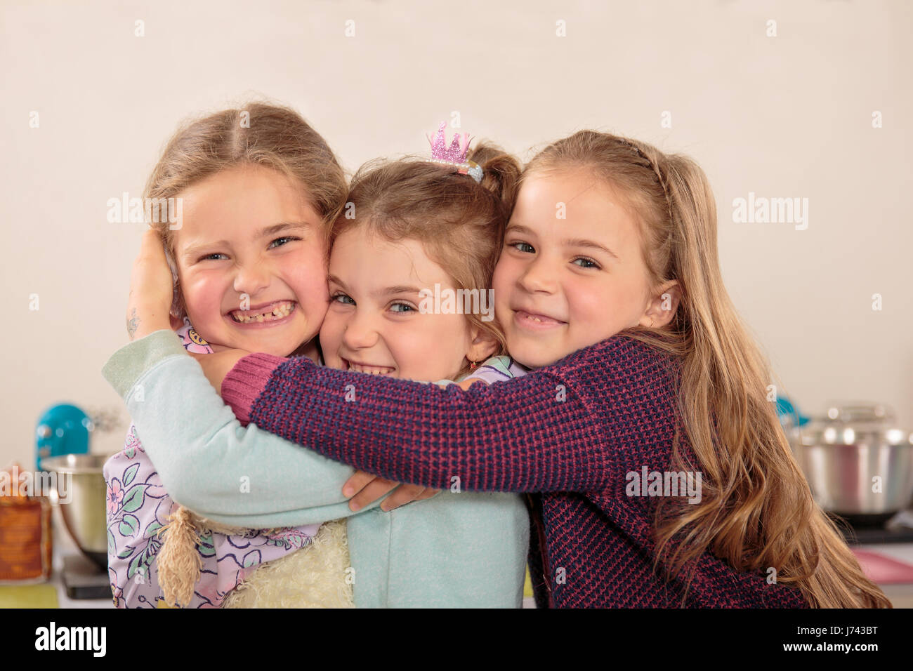 Three little friends hug each other on a couch Stock Photo - Alamy