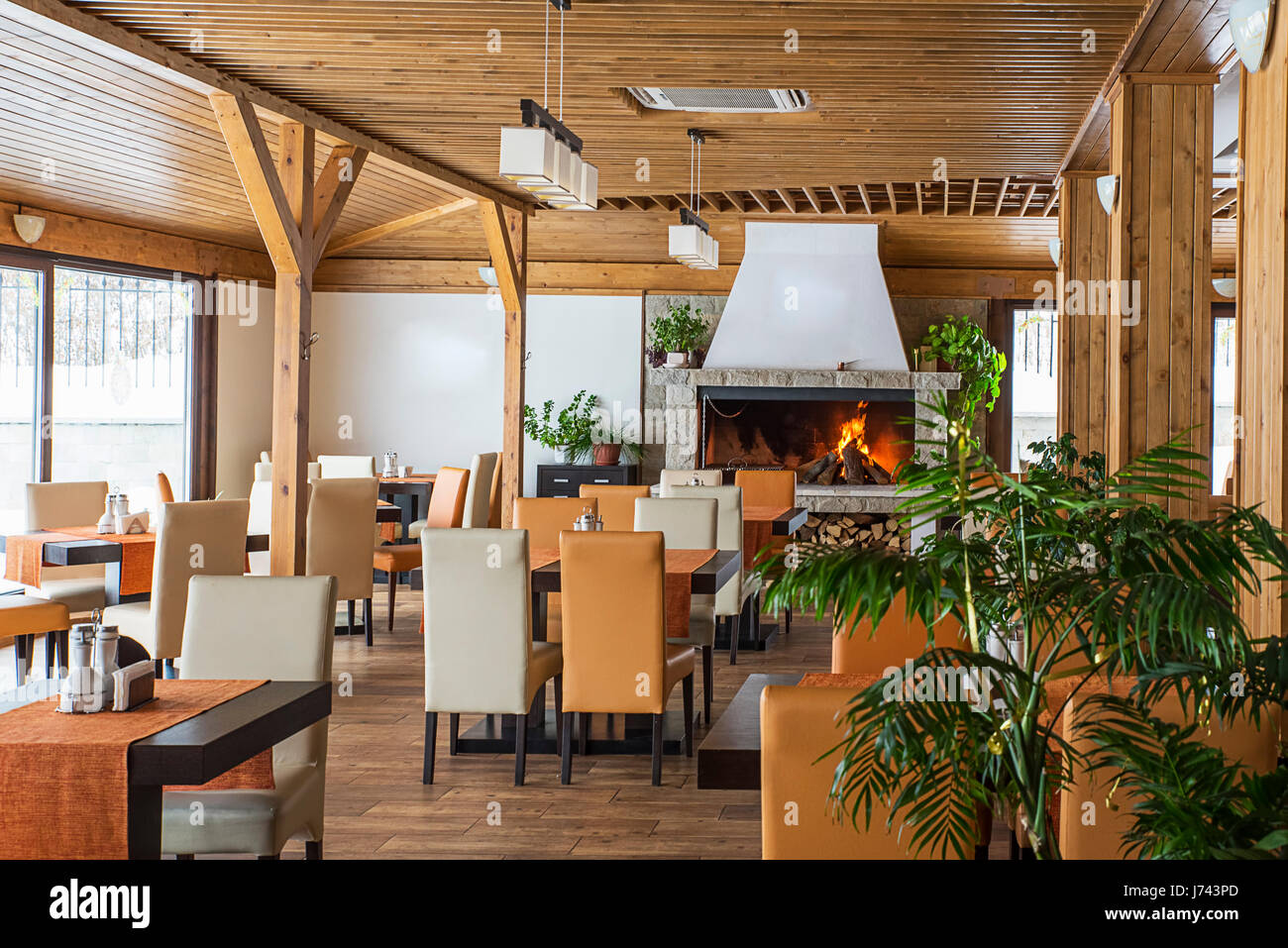Restaurant with a wooden interior with fireplace and fire Stock Photo ...