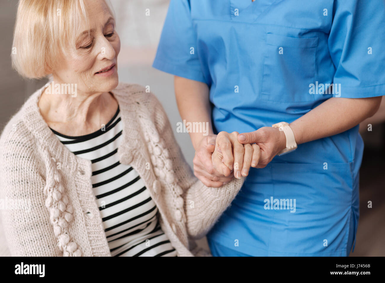 Feeble nice lady having her pulse checked Stock Photo - Alamy