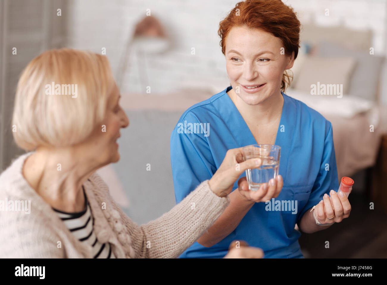 Hardworking kind doctor serving her patient pills Stock Photo - Alamy