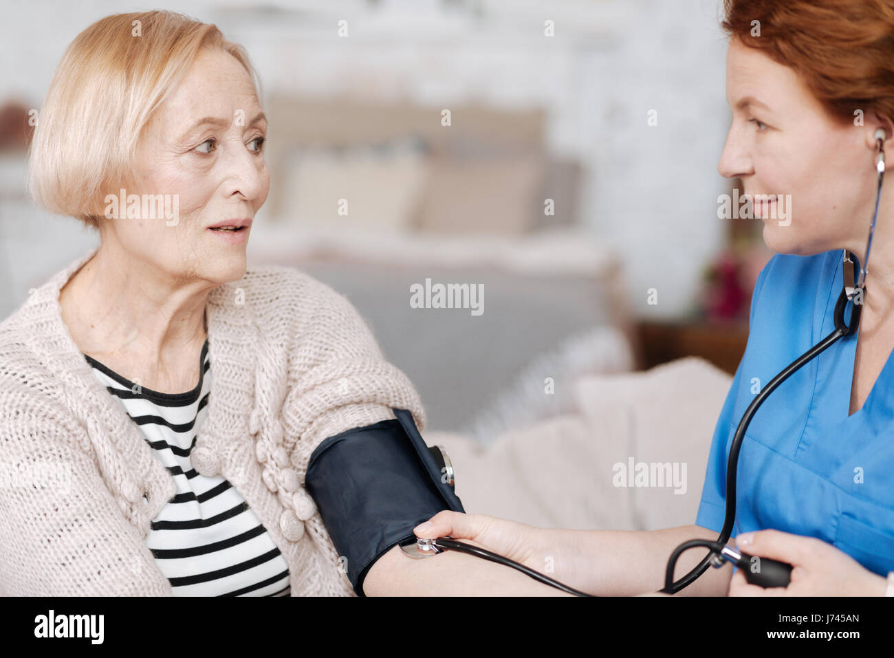 Mindful thorough doctor doing patients blood pressure Stock Photo - Alamy