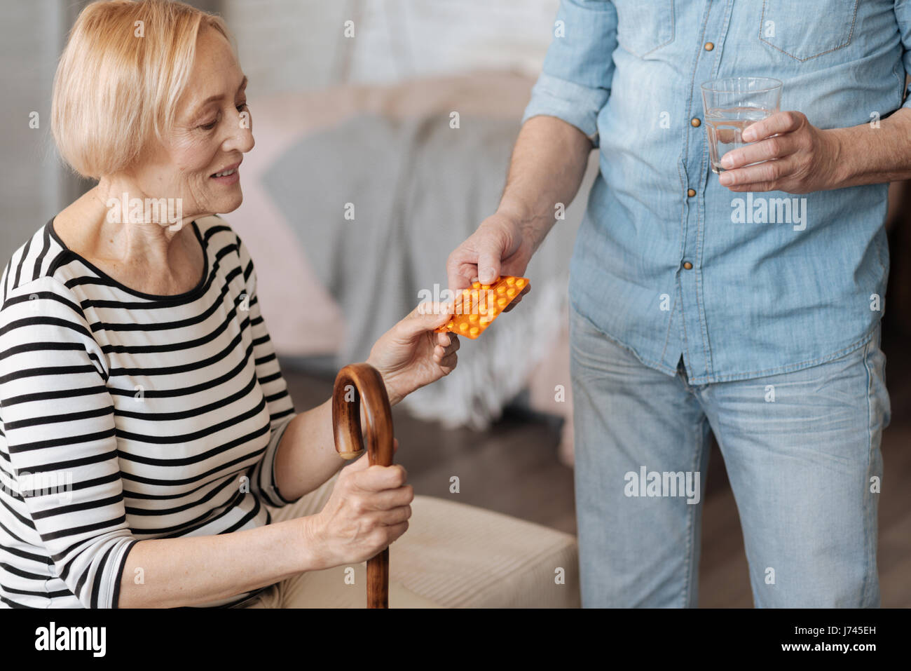 Aged feeble lady having her pill served Stock Photo - Alamy
