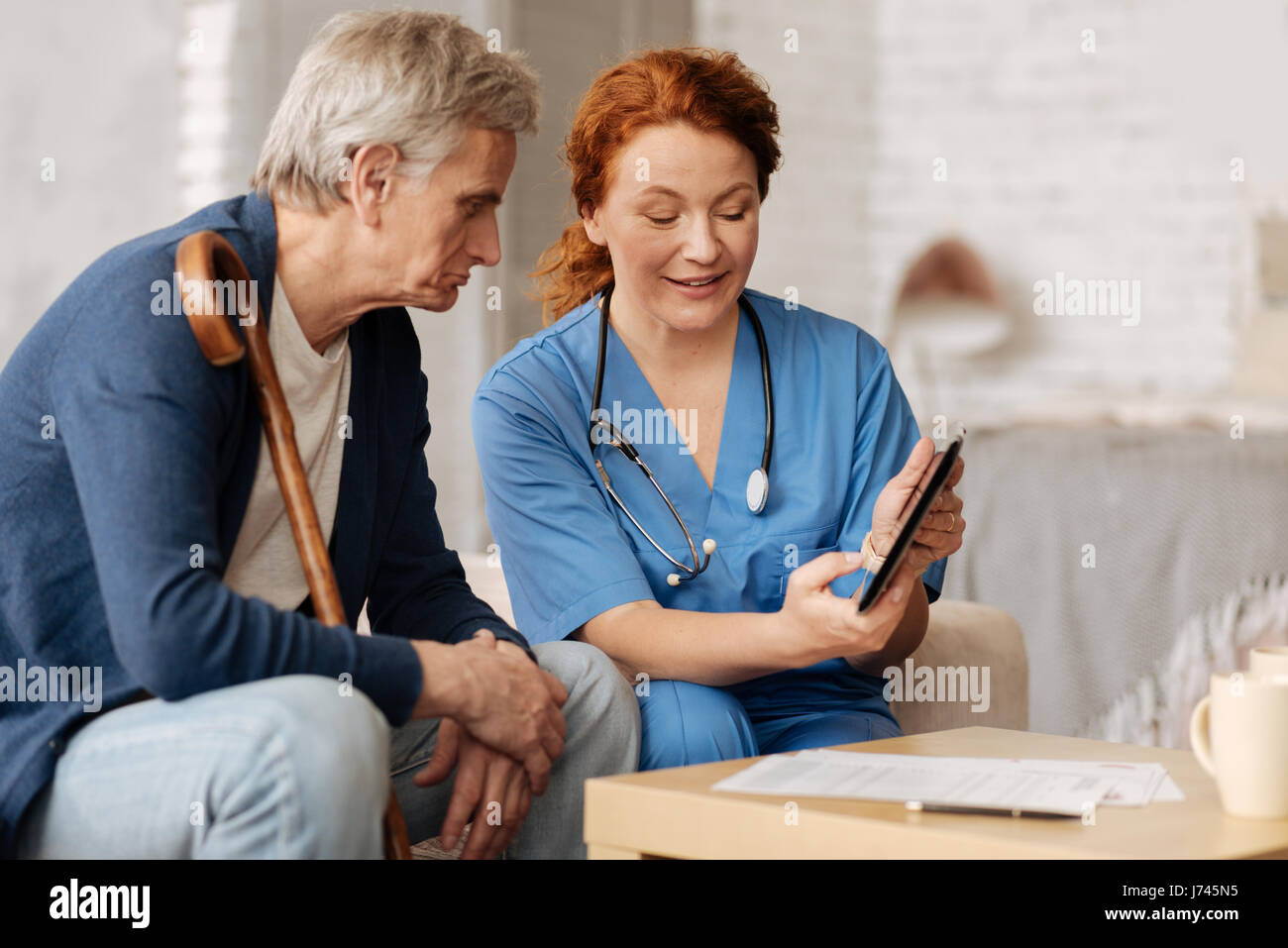 Joyful excited nurse explaining something to her patient Stock Photo ...