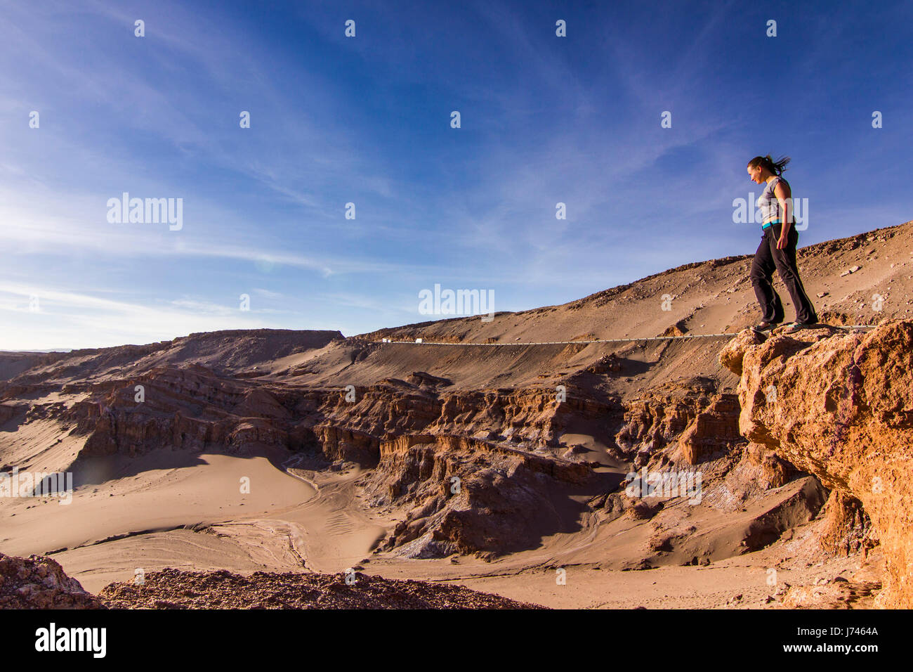 girl standing on a cliff in salty Moon valley in atacama desert at ...