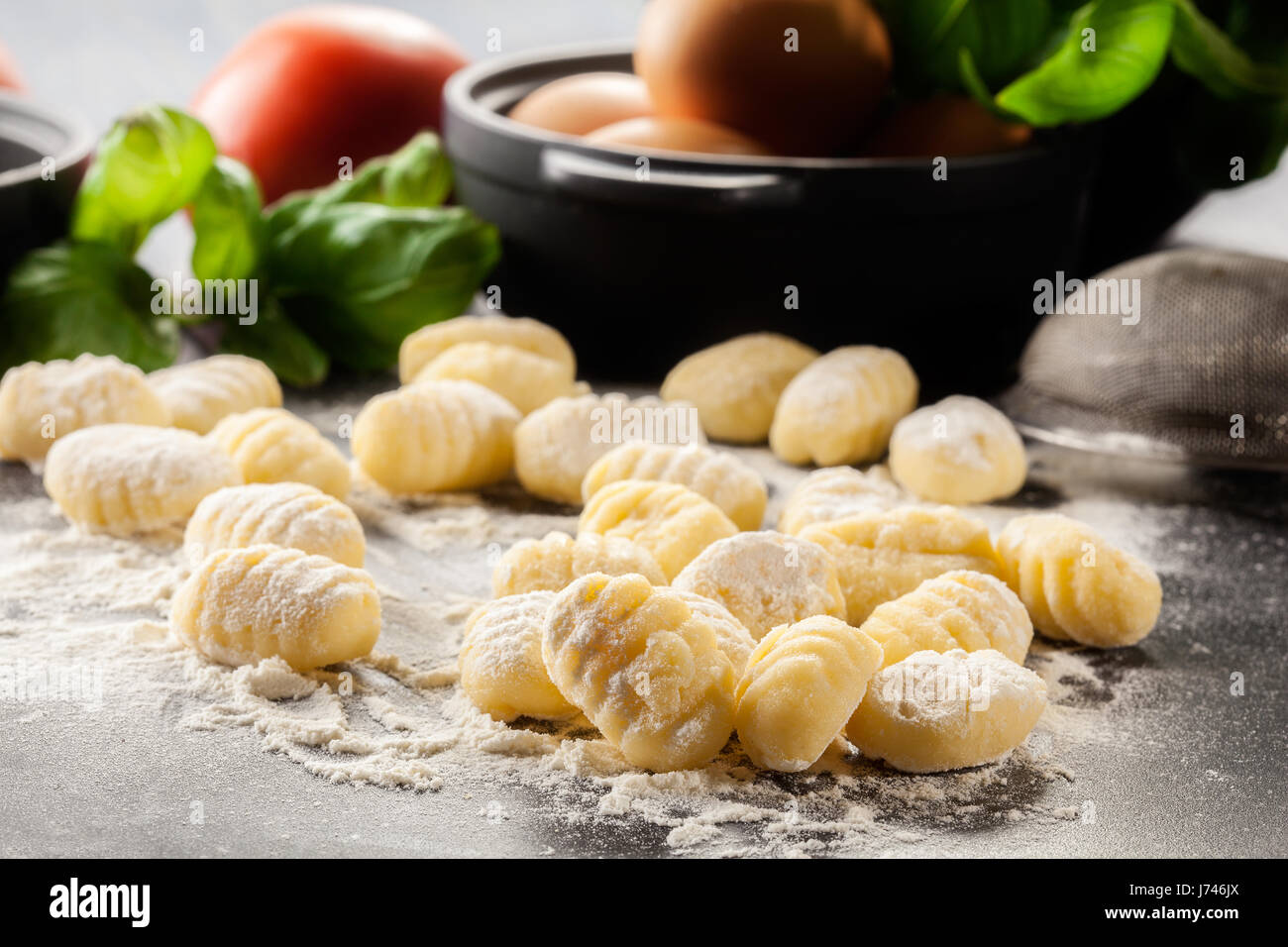 Uncooked homemade gnocchi on black cutting board Stock Photo - Alamy