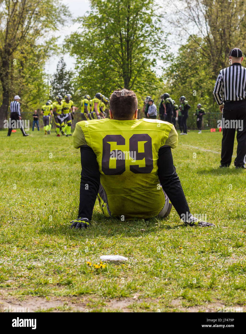 American Football Player Sitting on Grass Stock Photo - Alamy