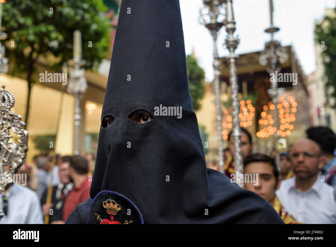 Nazarene penitent with the typical conical hood walking in front of a ...