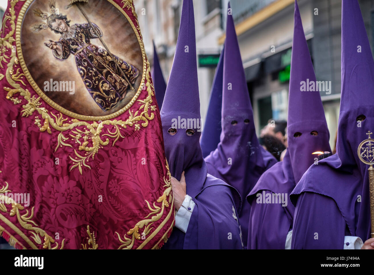 Nazarenos participating in a religious procession, with the traditional ...