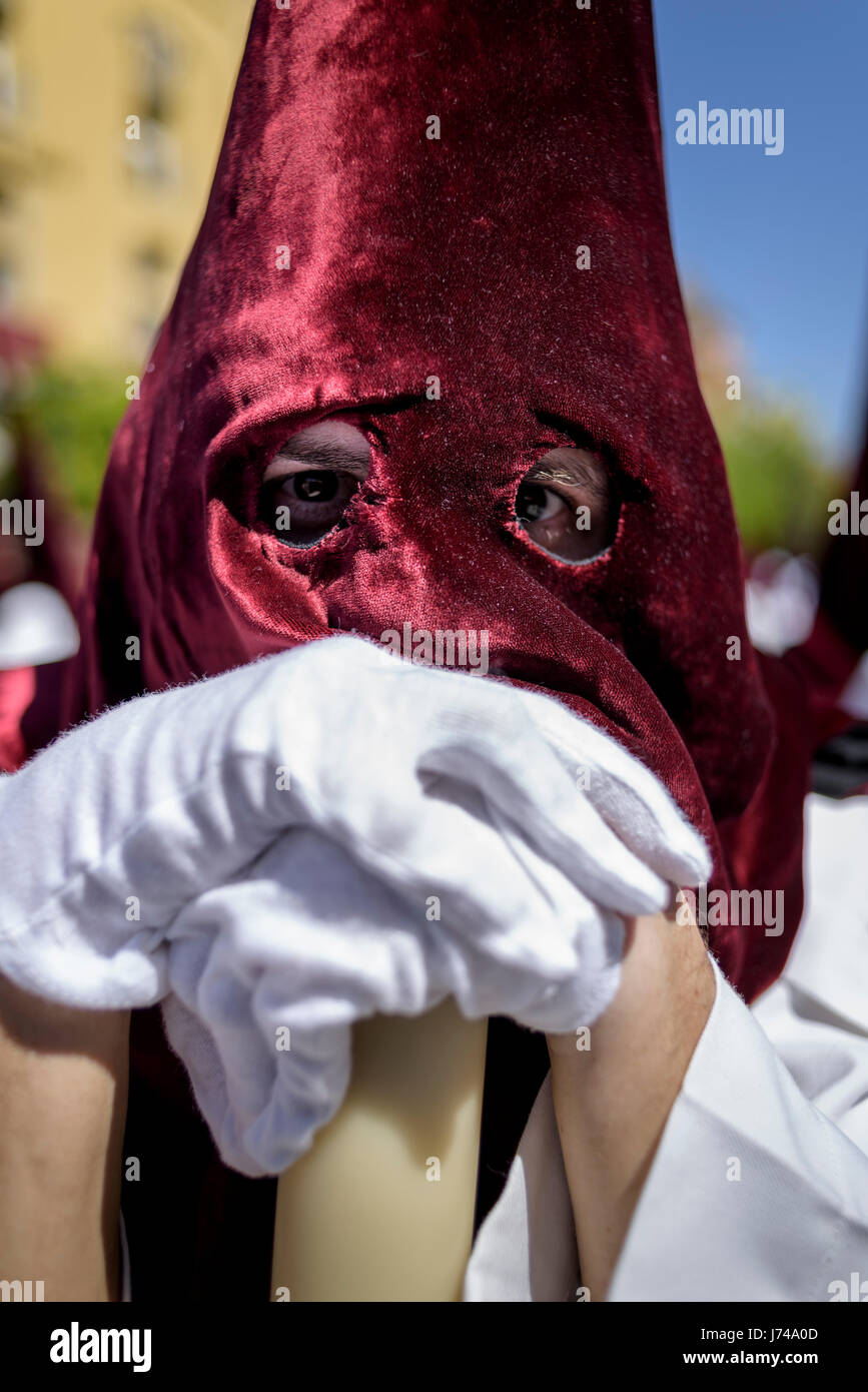 Portrait of a Nazarene penitent with red hood and white robes ...
